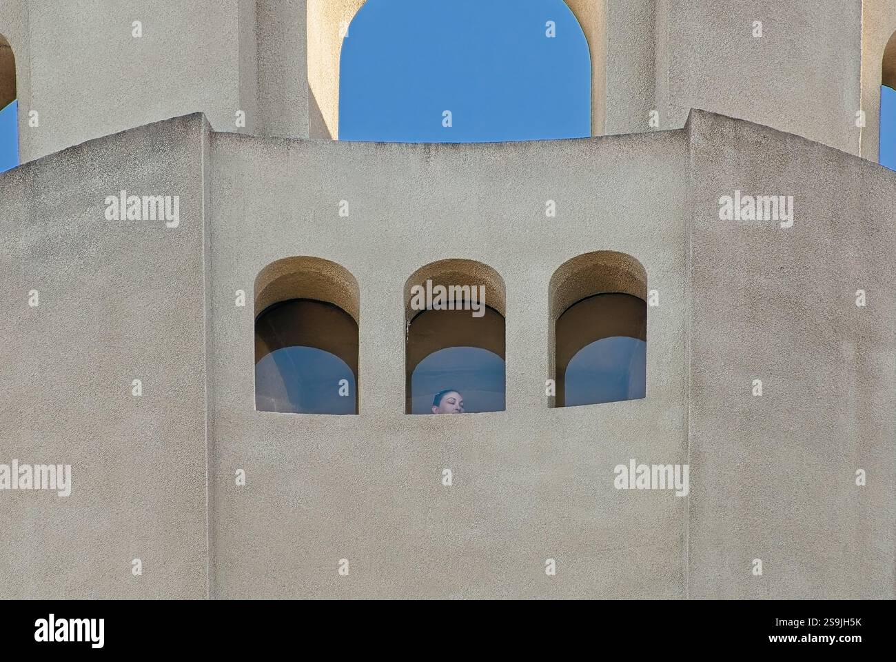 Tourist looking through arched window at top of Coit Tower in San ...