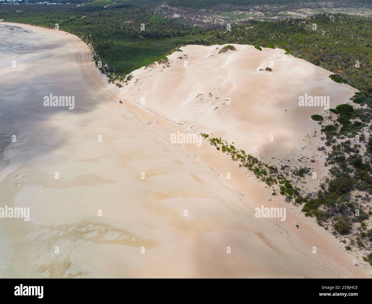 Aerial view of a coastal sand dune and wide beach at low tide at Gunyah ...