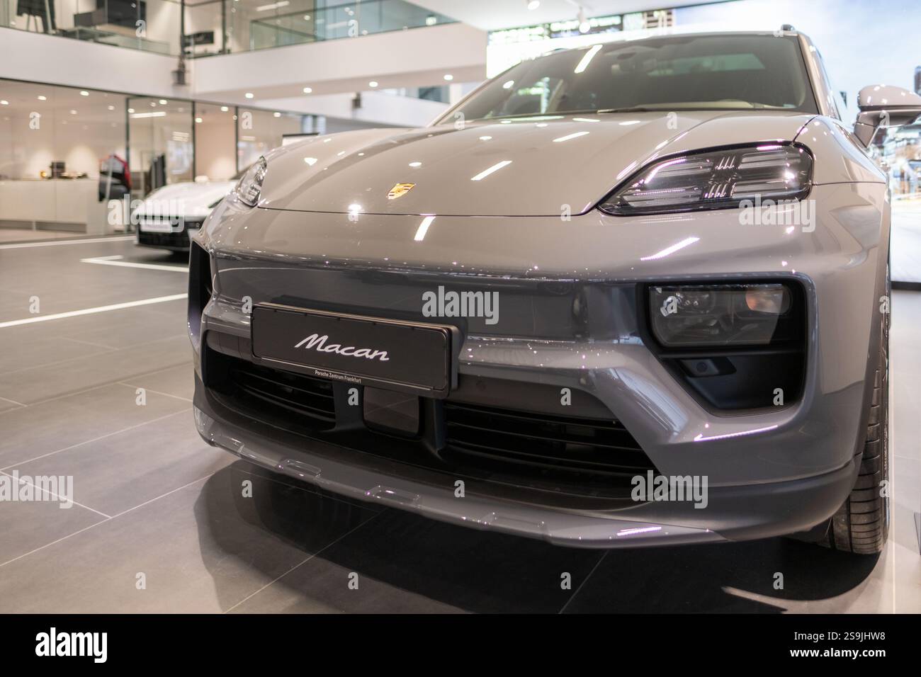 electric grey Porsche Macan GTS in auto showroom, advanced automotive ...