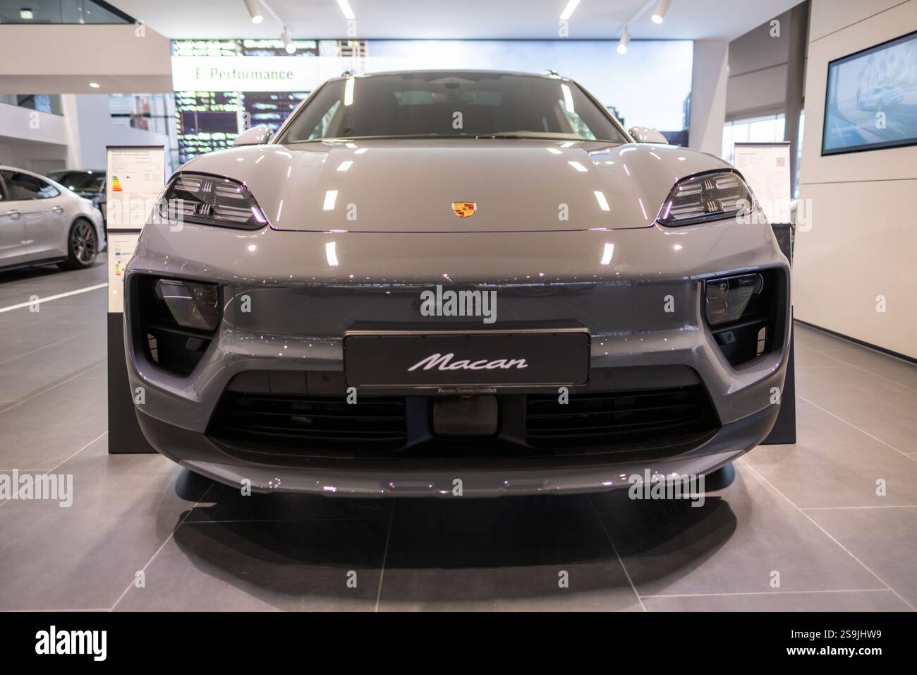 electric grey Porsche Macan in auto showroom, advanced automotive technology, German engineering ...