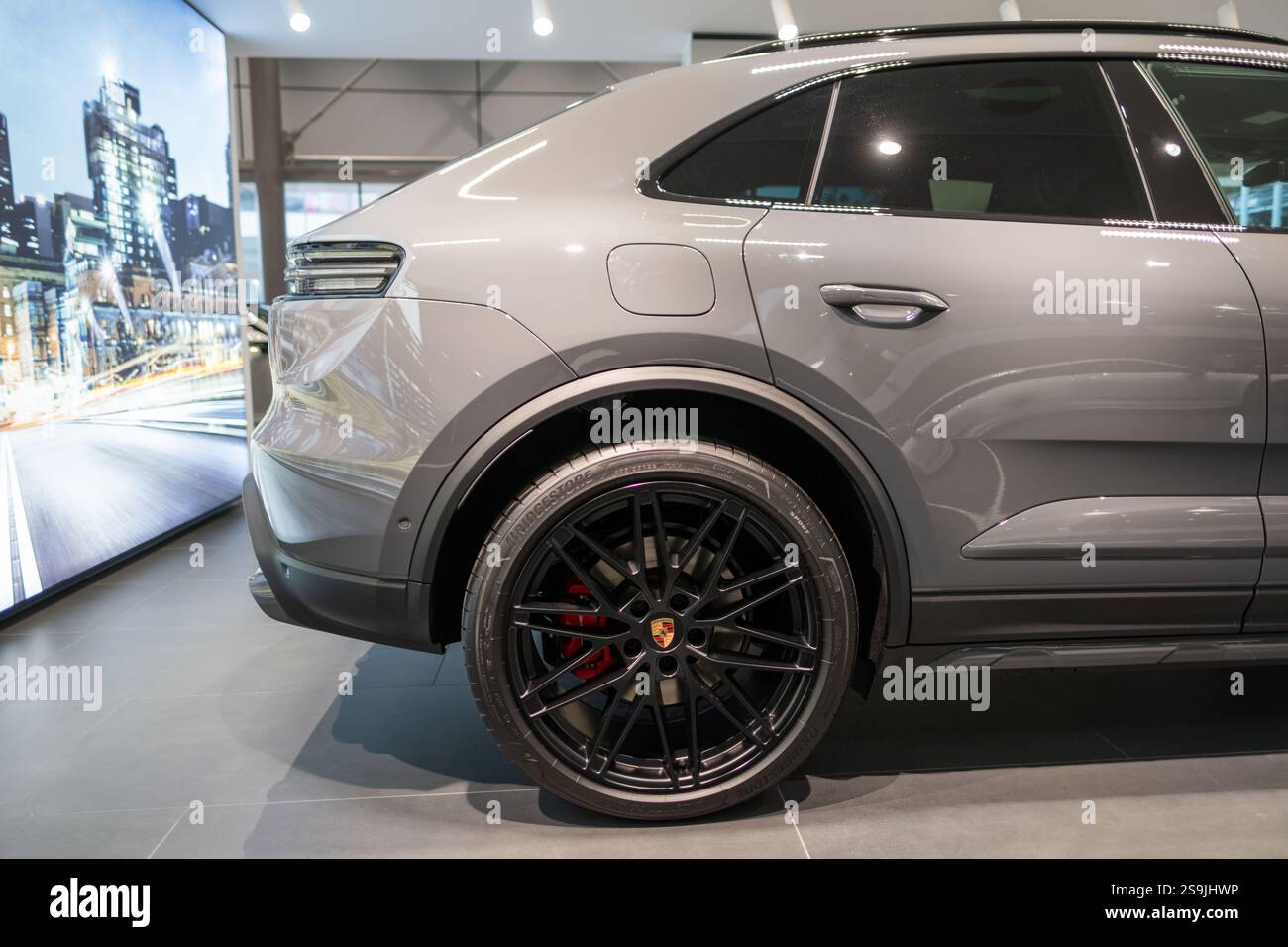 electric grey Porsche Macan GTS in auto showroom, advanced automotive ...