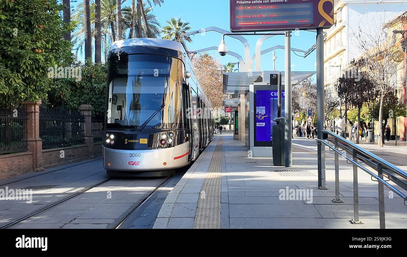 A light rail tram is leaving a metro station outdoors in Seville, Spain ...