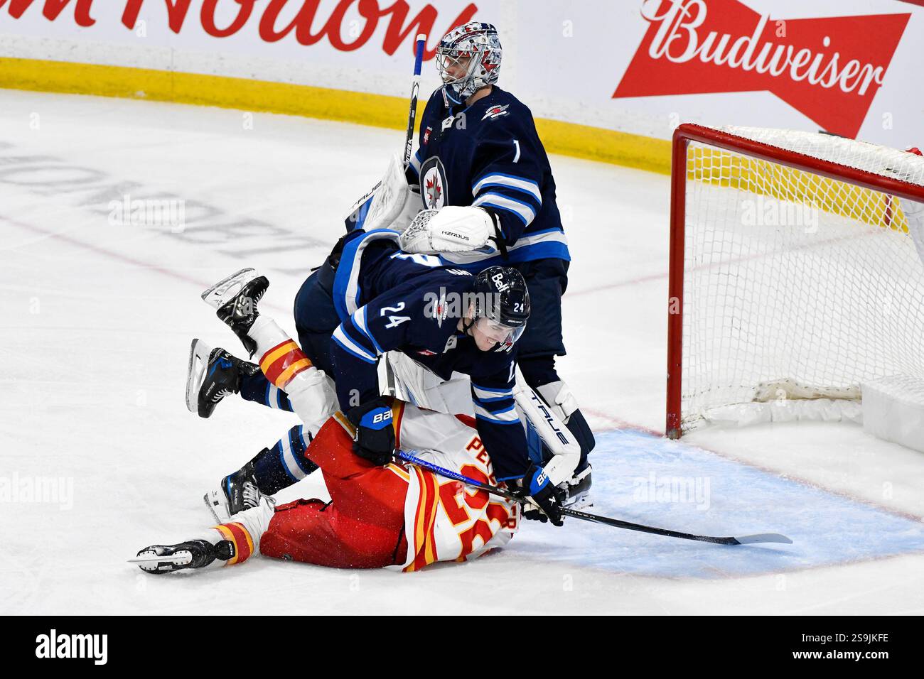 Calgary Flames' Jakob Pelletier (22) is dumped by Winnipeg Jets' Haydn ...
