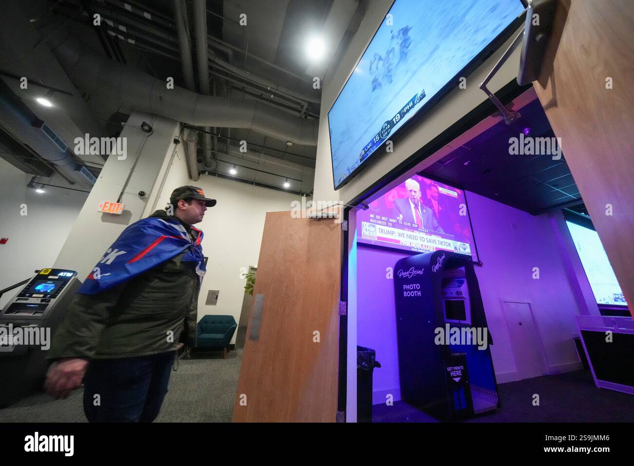 A supporter of President-elect Donald Trump enters a restaurant showing ...