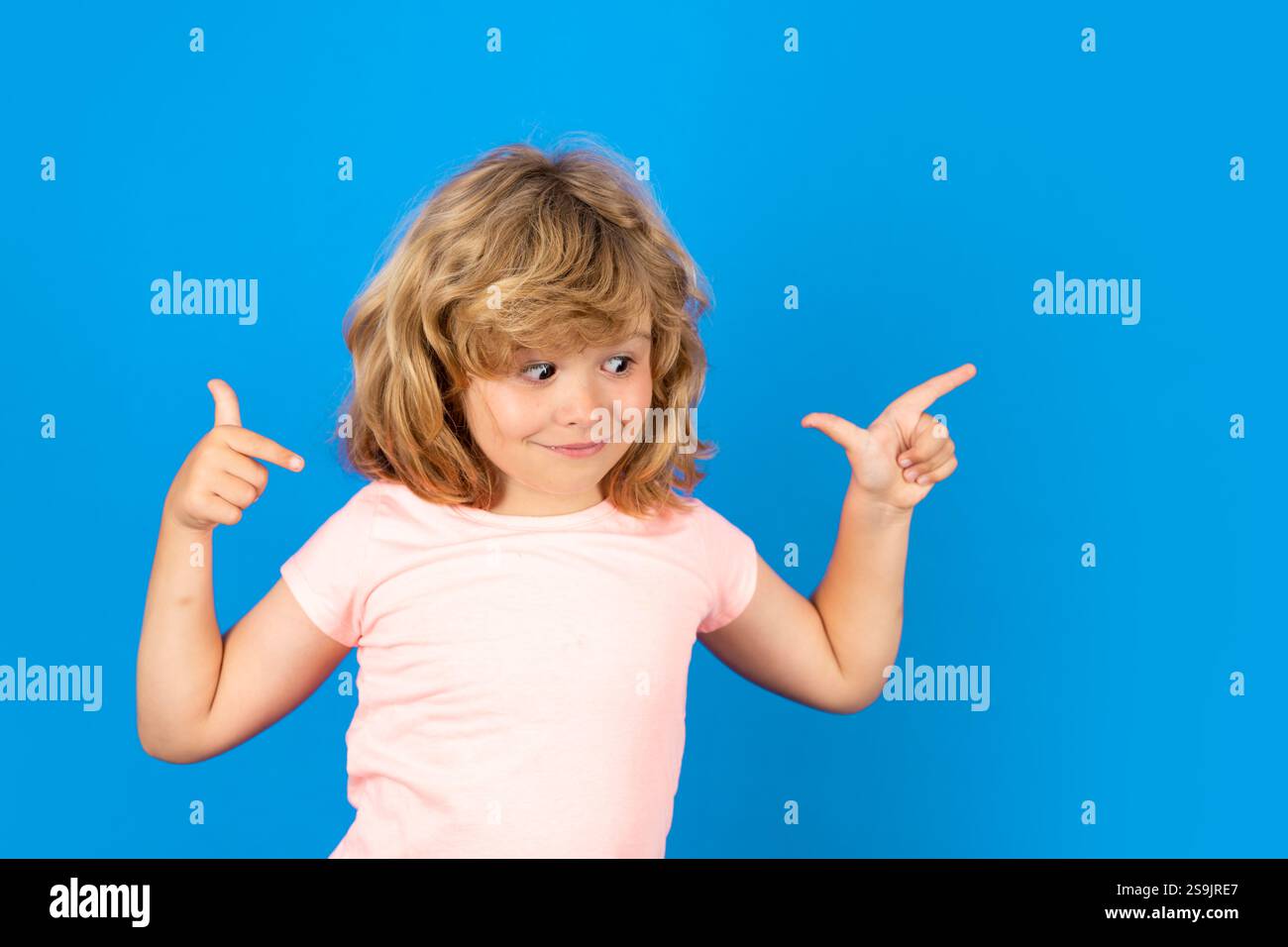Funny child pointing away on isolated studio background. Kid with index ...