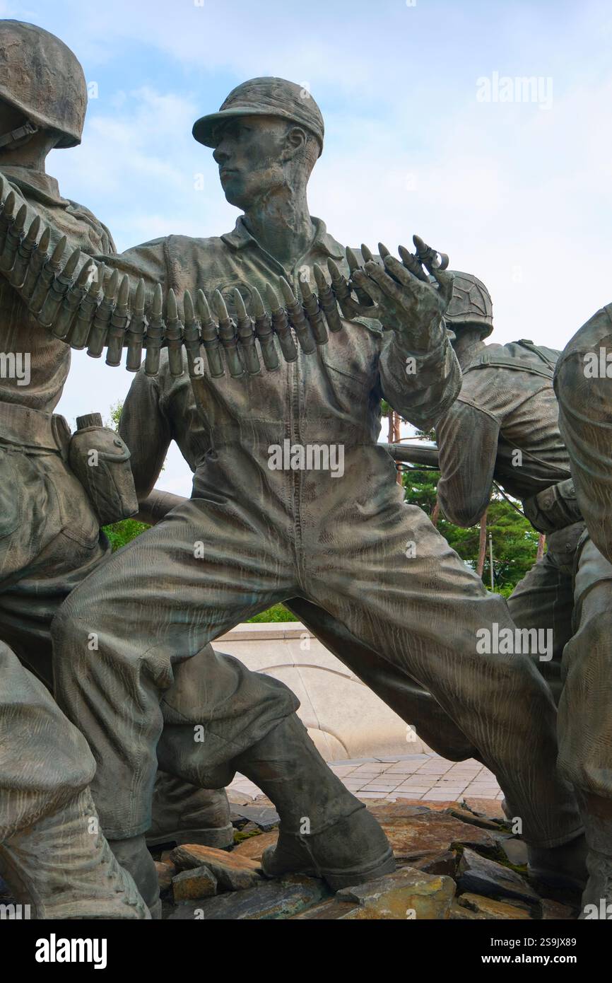 Detail of a soldier feeding bullets, ammunition in a large, bronze ...