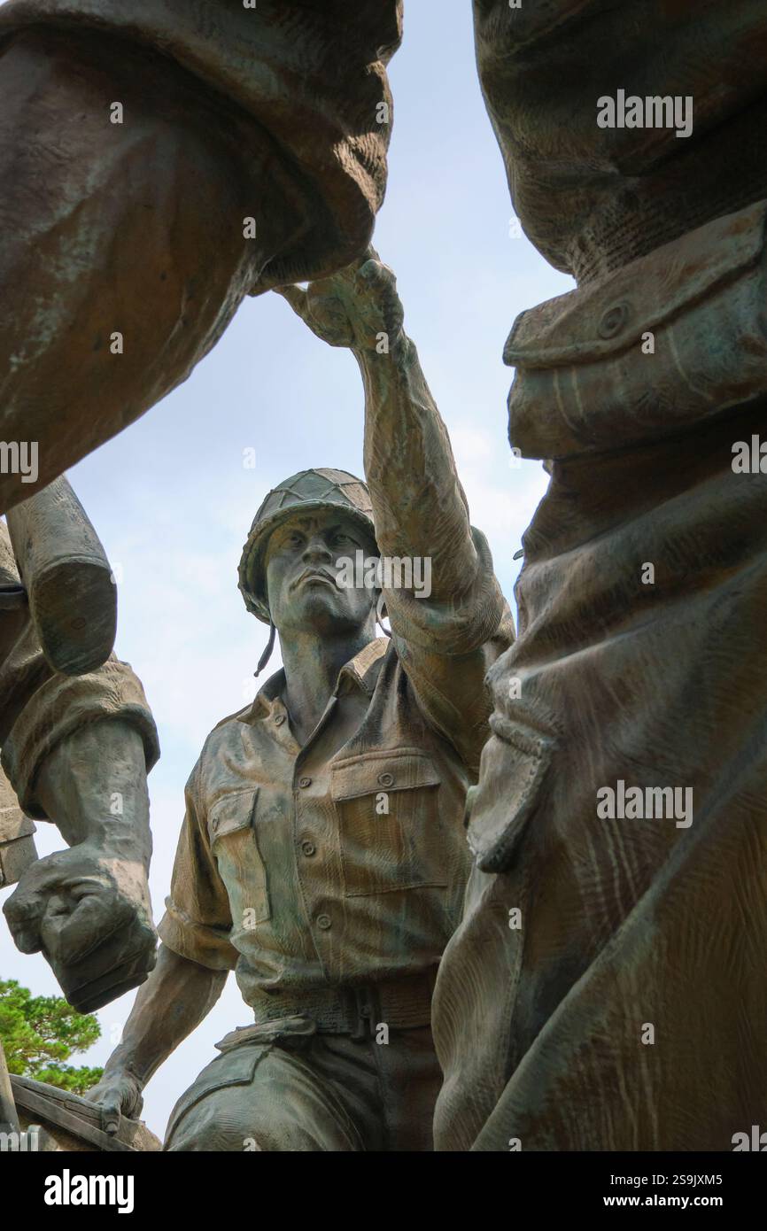 Detail of a soldier reaching in a large, bronze sculpture of a fighting ...