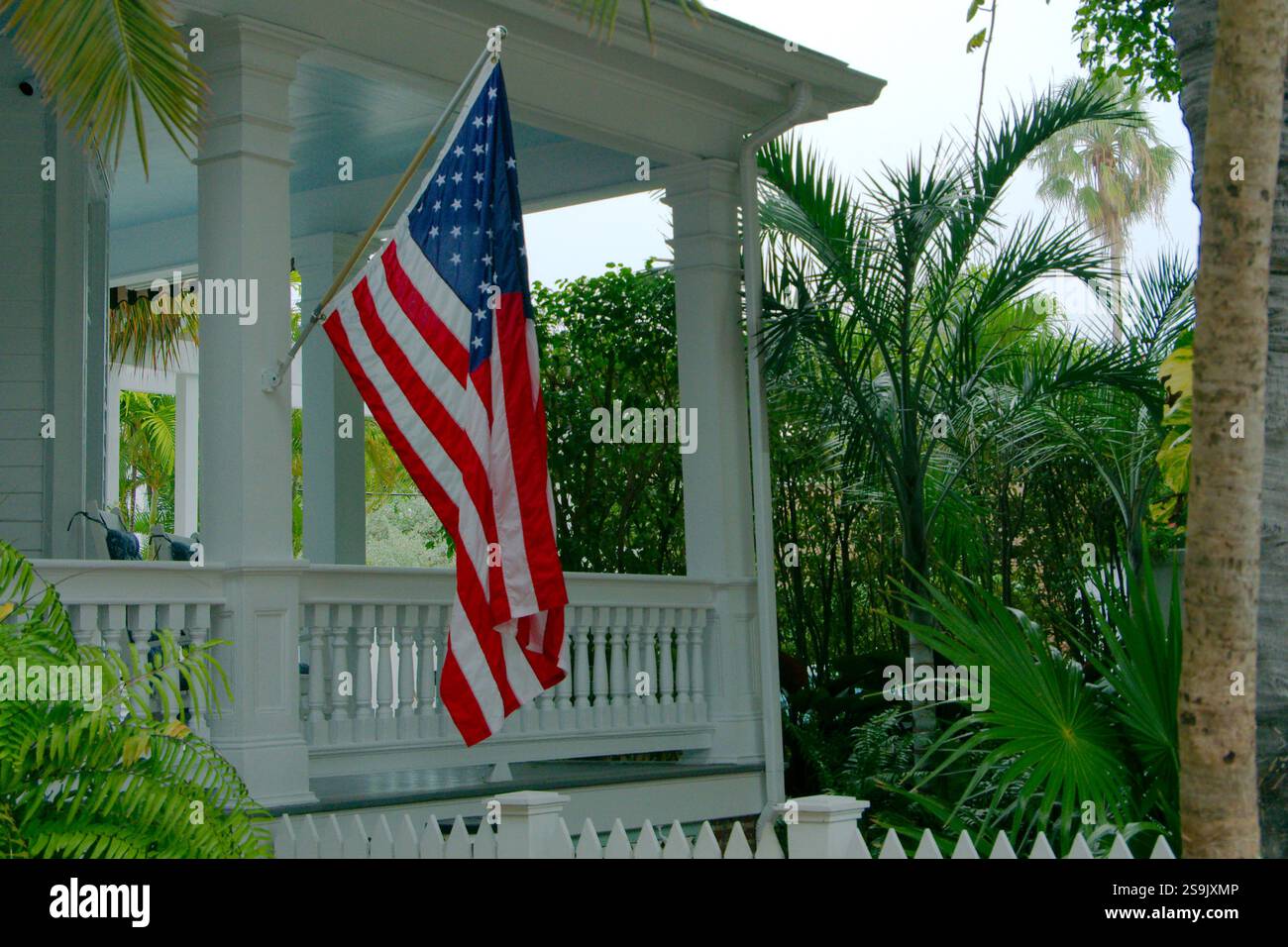 Red, White and blue American flag hanging from a pole on the post of a ...