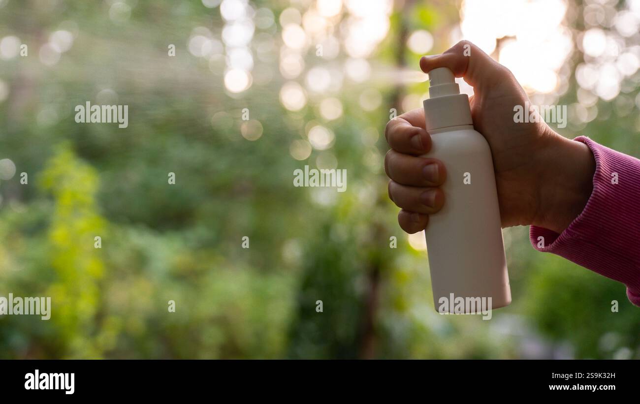 Hand applying insect repellent mosquito insecticide spray to kill flies ...