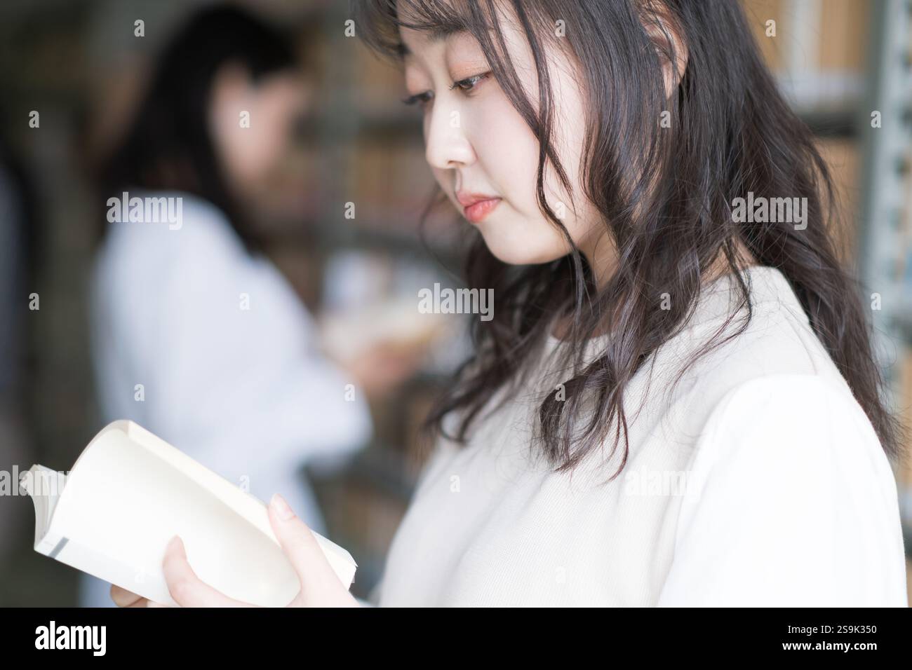 University student reading a book Stock Photo - Alamy