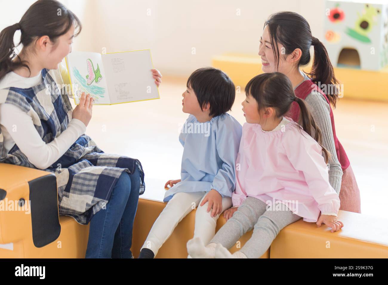 Childcare worker reading to a child Stock Photo - Alamy