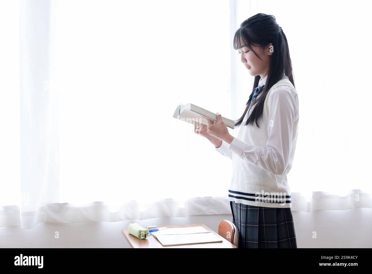 High school student reading a textbook Stock Photo - Alamy
