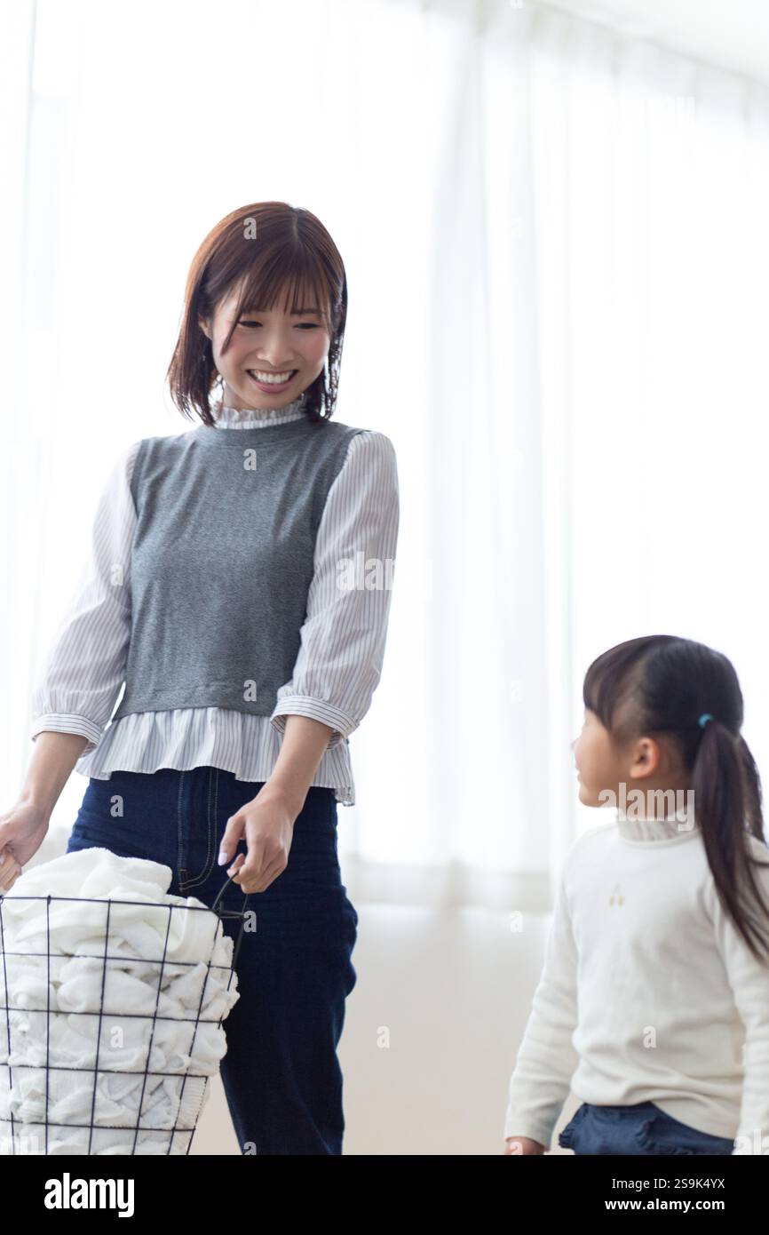 Parent and child carrying laundry Stock Photo - Alamy