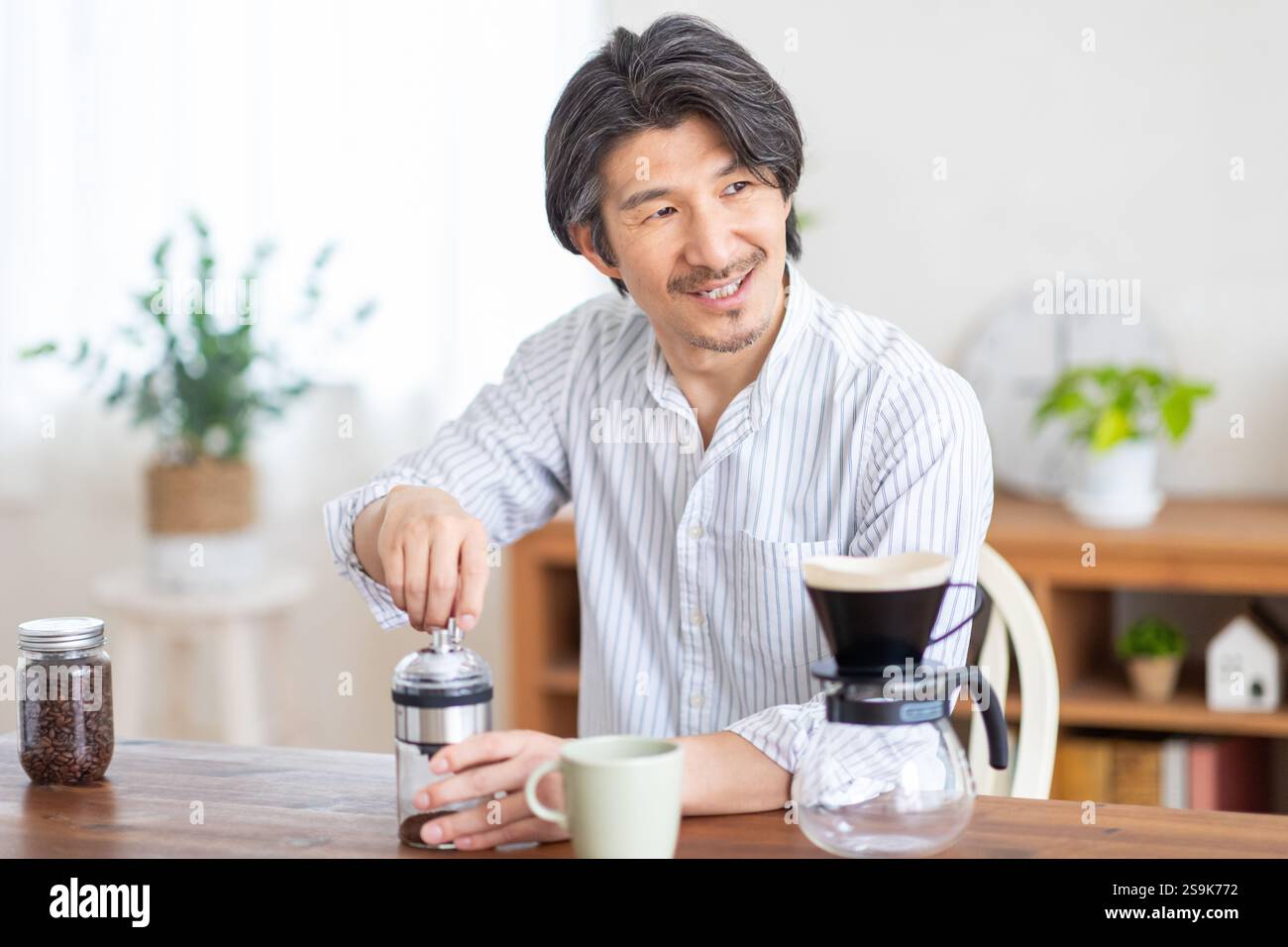 Man grinding coffee beans Stock Photo - Alamy