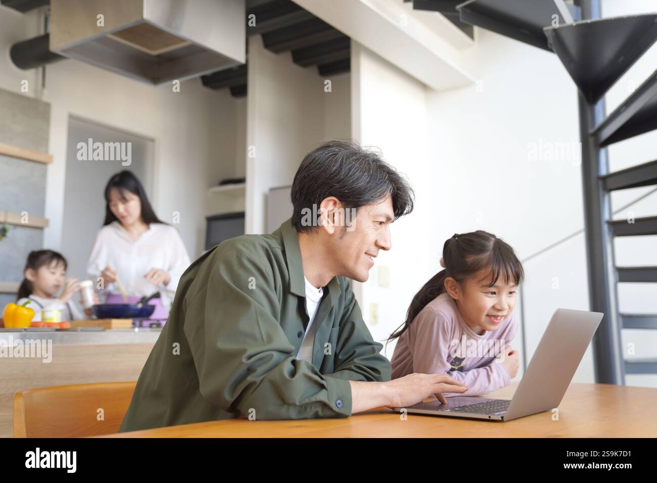 Parents and children looking at a computer Stock Photo - Alamy