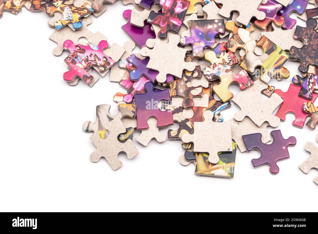 a pile of jigsaw puzzle pieces haphazardly scattered across a stark ...
