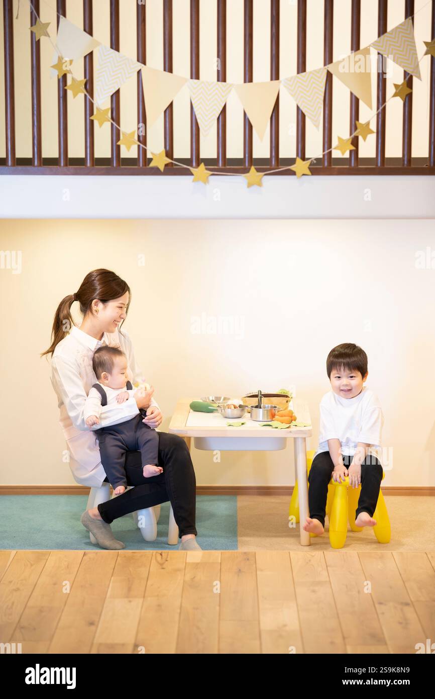 Childcare woman playing with children Stock Photo - Alamy