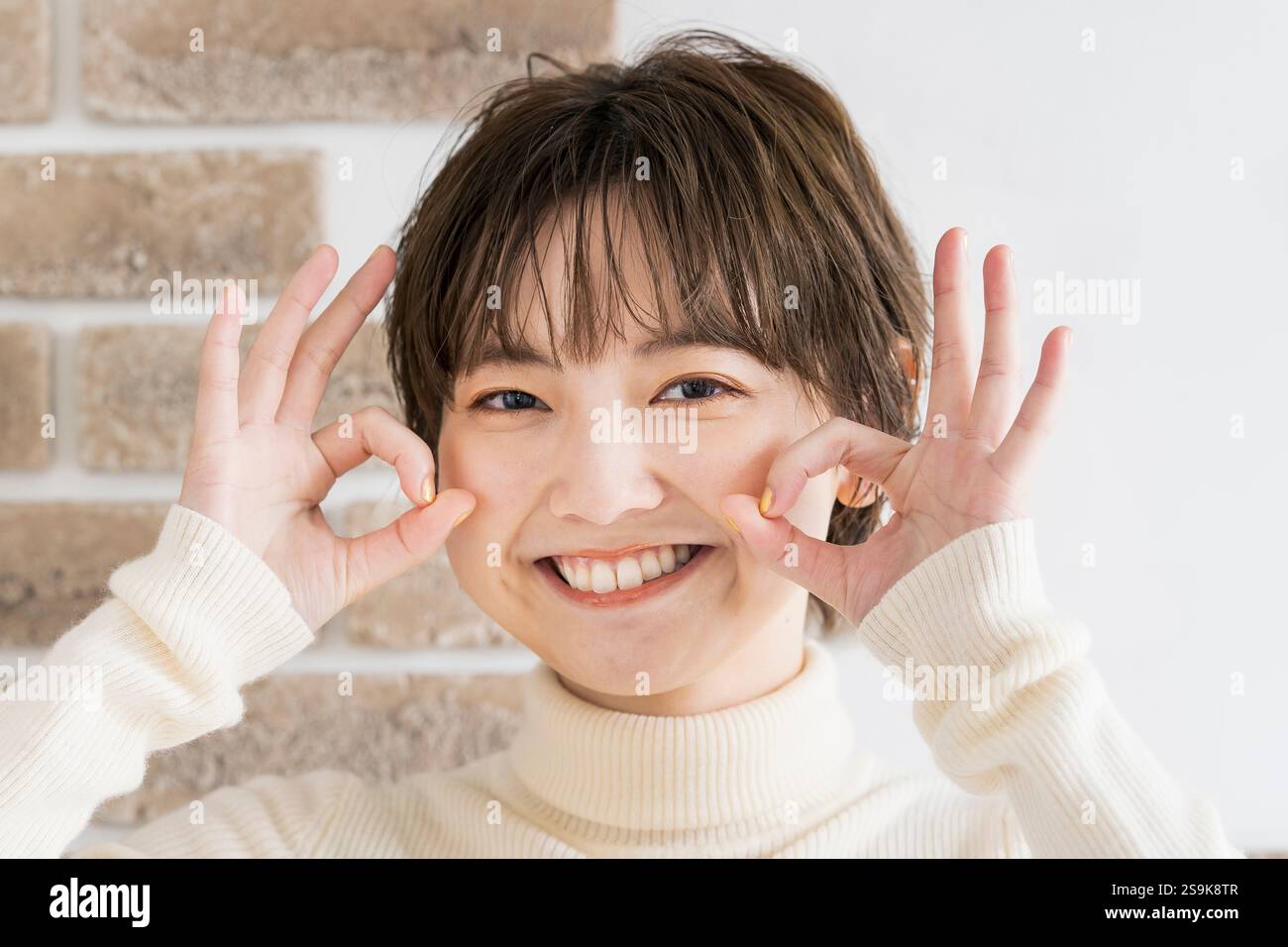Young women making the ‘OK’ sign Stock Photo - Alamy