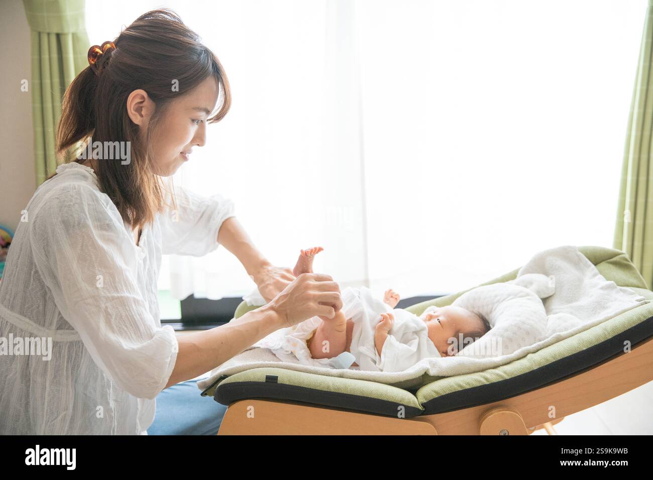 Mother changing baby's diaper Stock Photo - Alamy