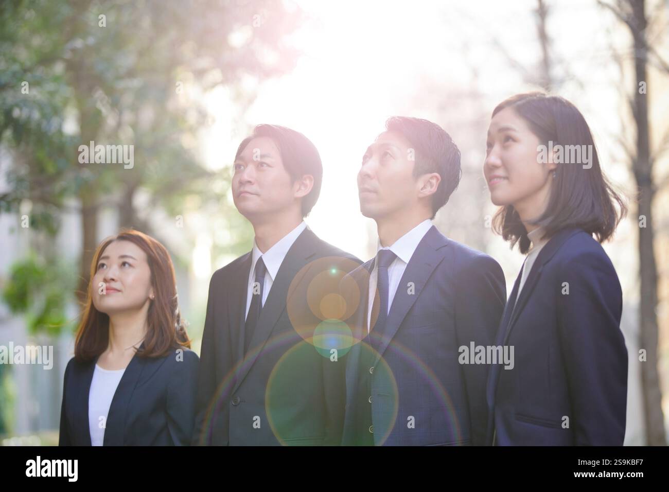 Four men and women in suits, business team Stock Photo - Alamy