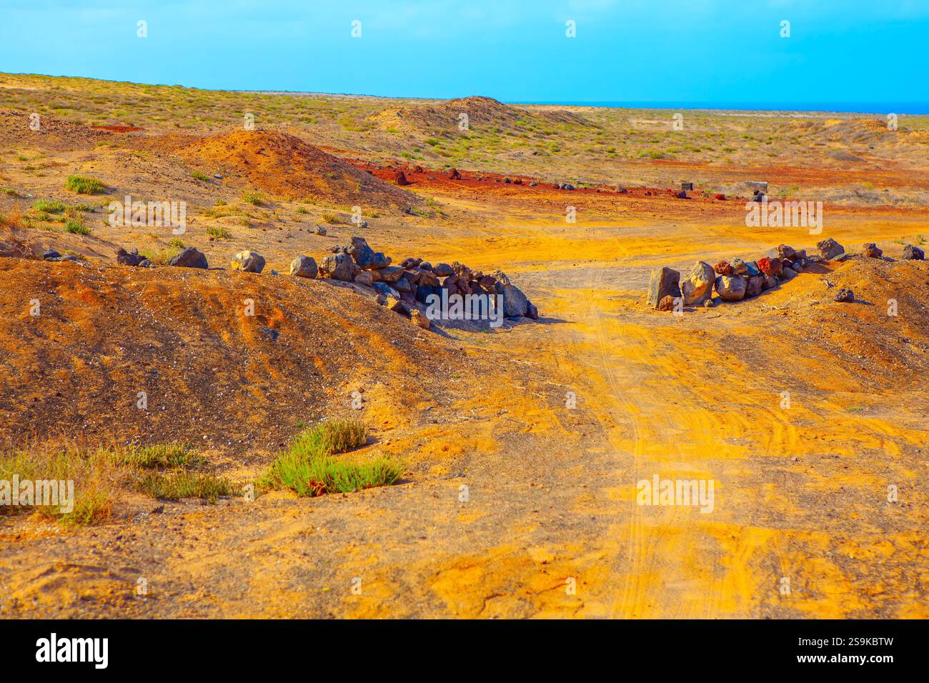 Dirt path winds through a rugged terrain with scattered rocks and ...