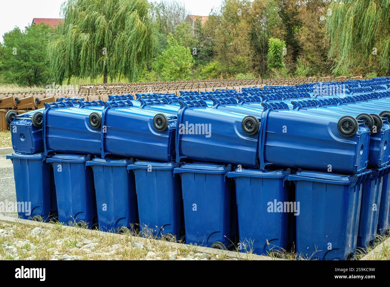 rows of new municipal colored trash cans with wheels, ready to be ...