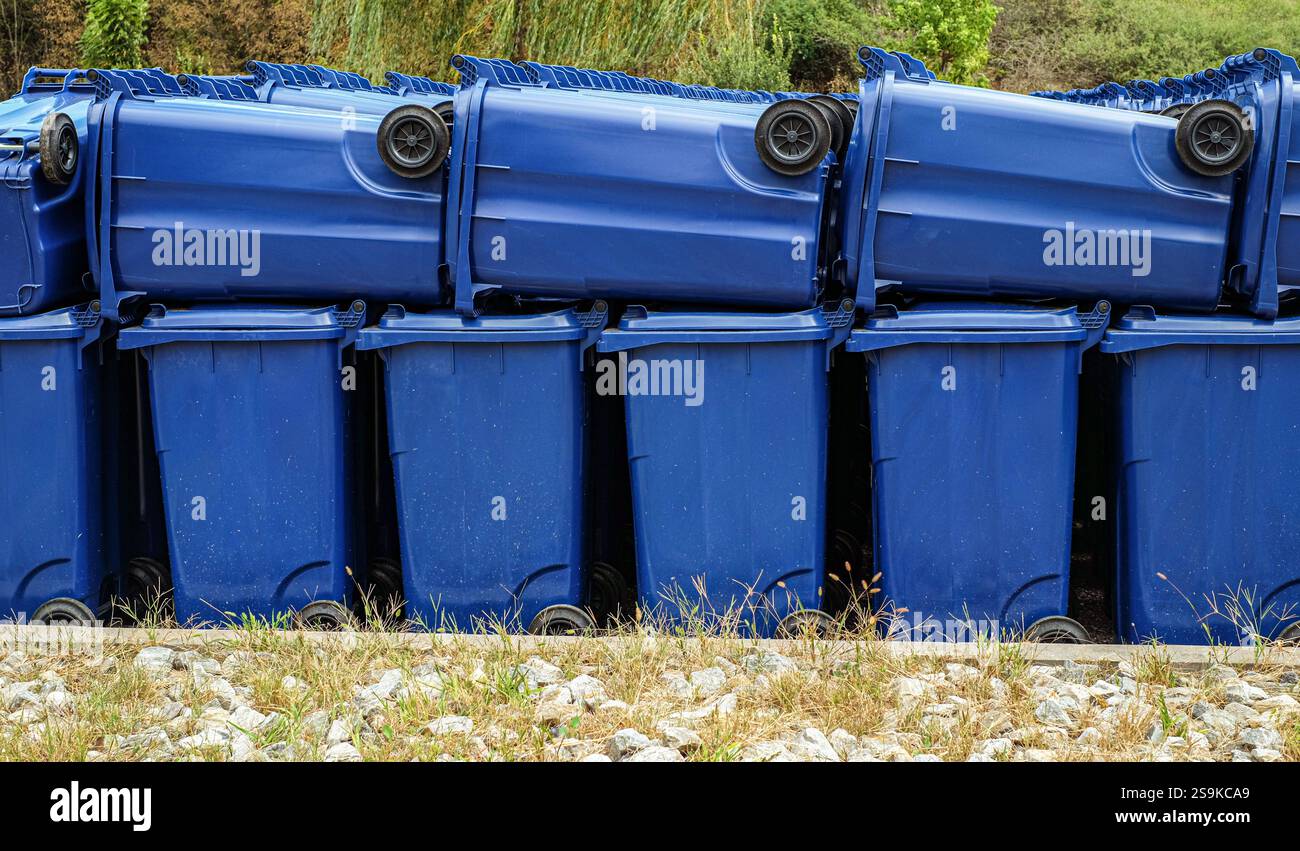 rows of new municipal colored trash cans with wheels, ready to be ...