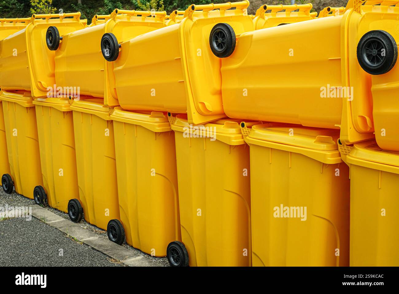rows of new municipal colored trash cans with wheels, ready to be ...