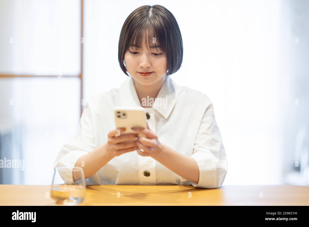 Woman operating smartphone in room Stock Photo - Alamy
