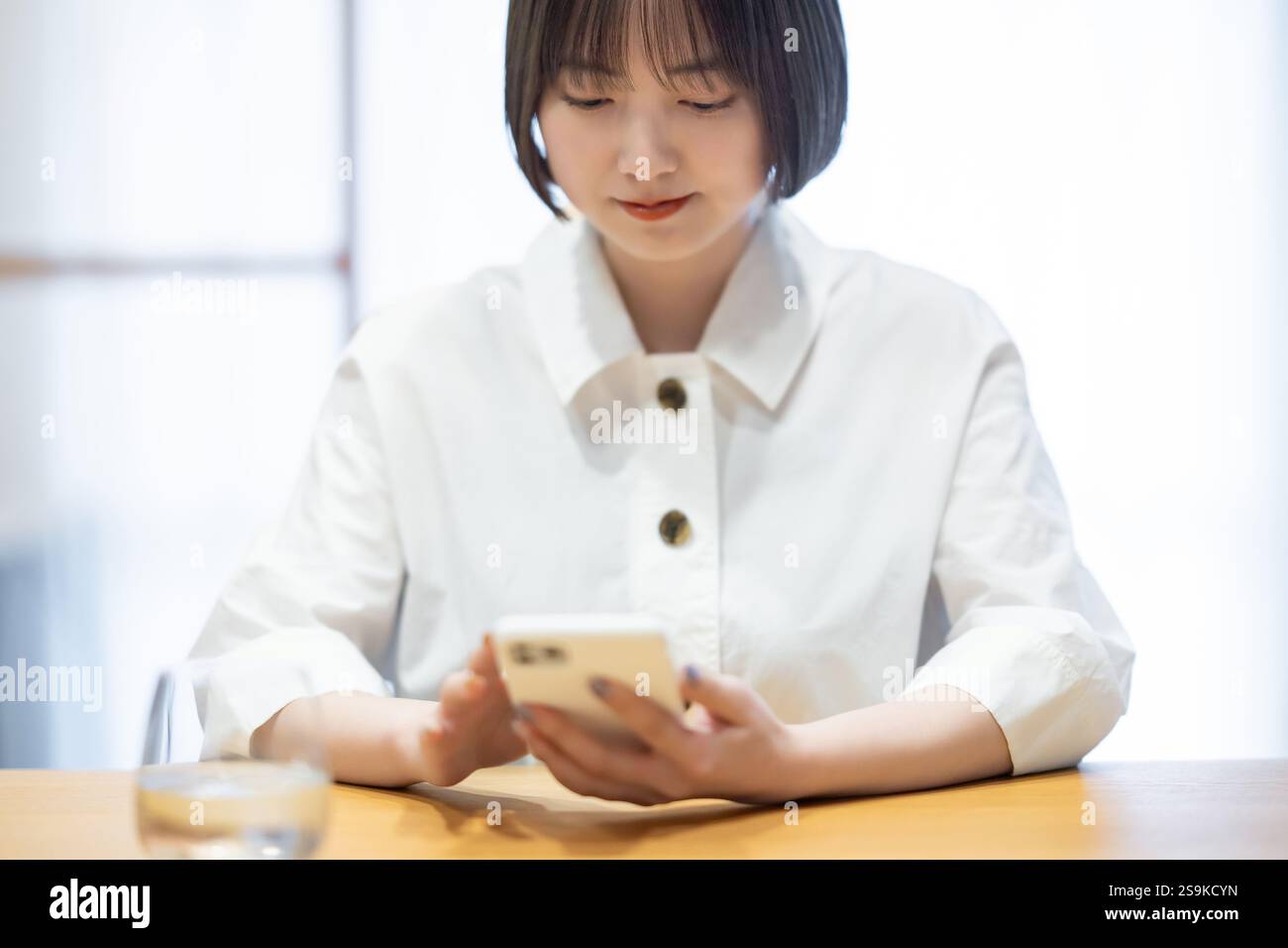 Woman operating smartphone in room Stock Photo - Alamy