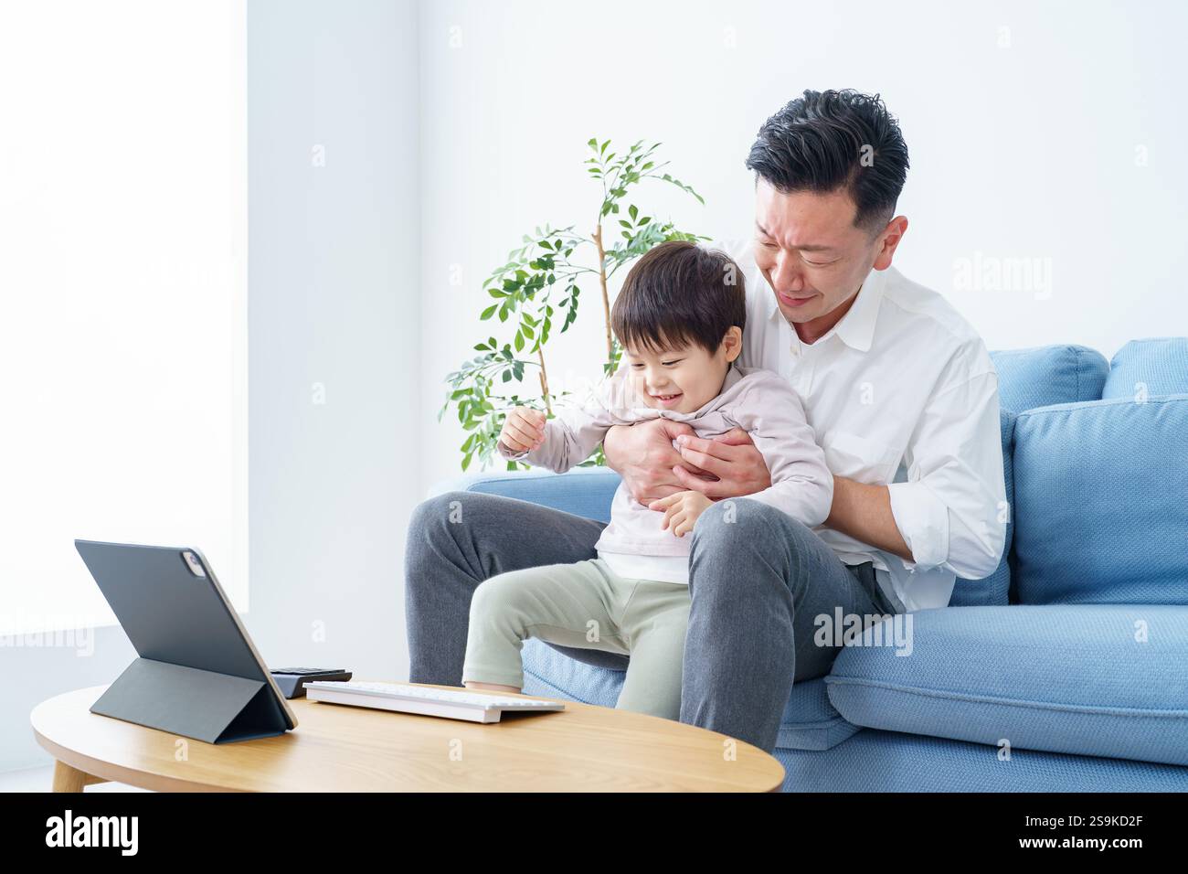 Child interrupting father teleworking Stock Photo - Alamy