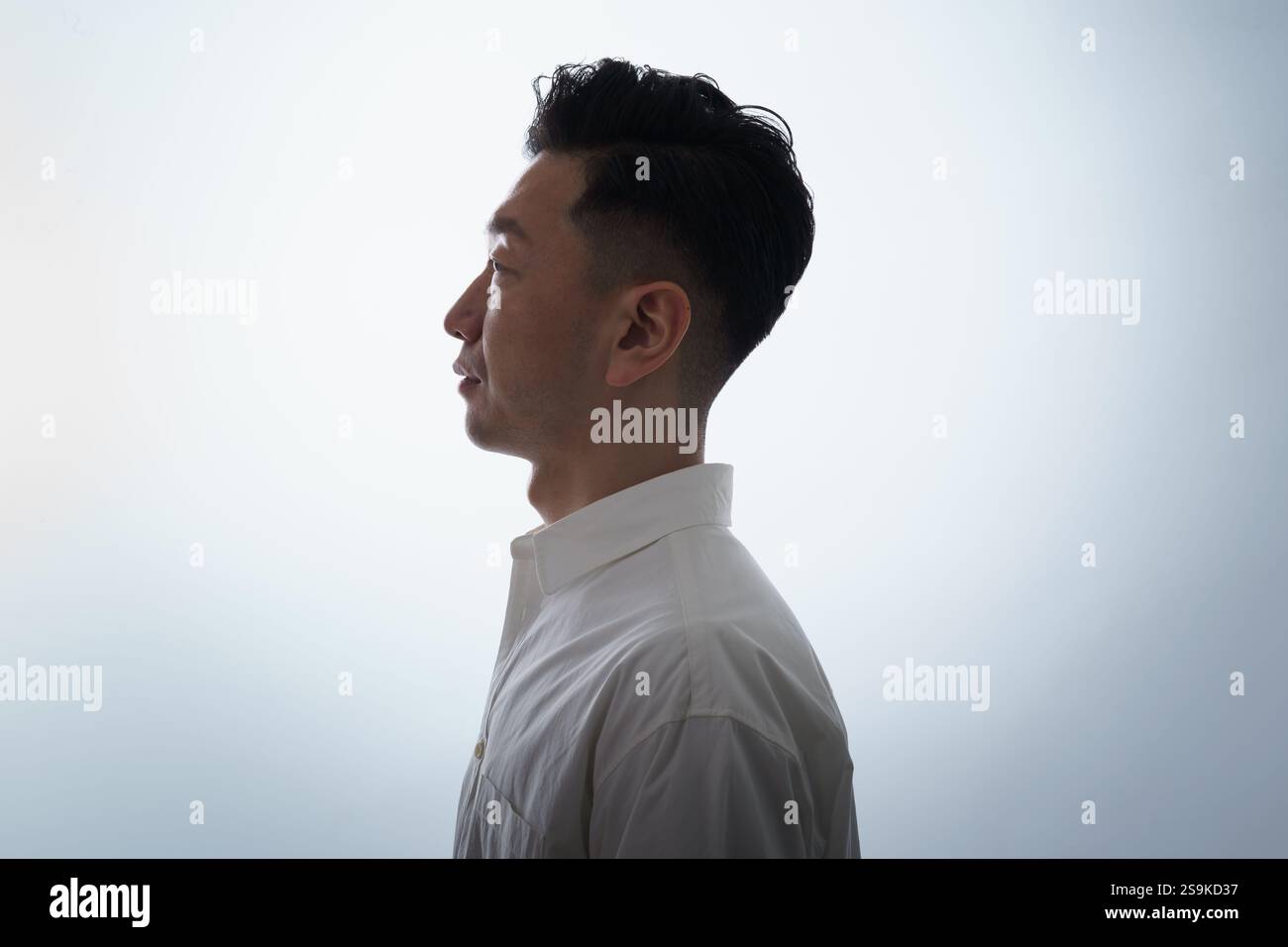 Middle man standing in front of white bag Stock Photo - Alamy