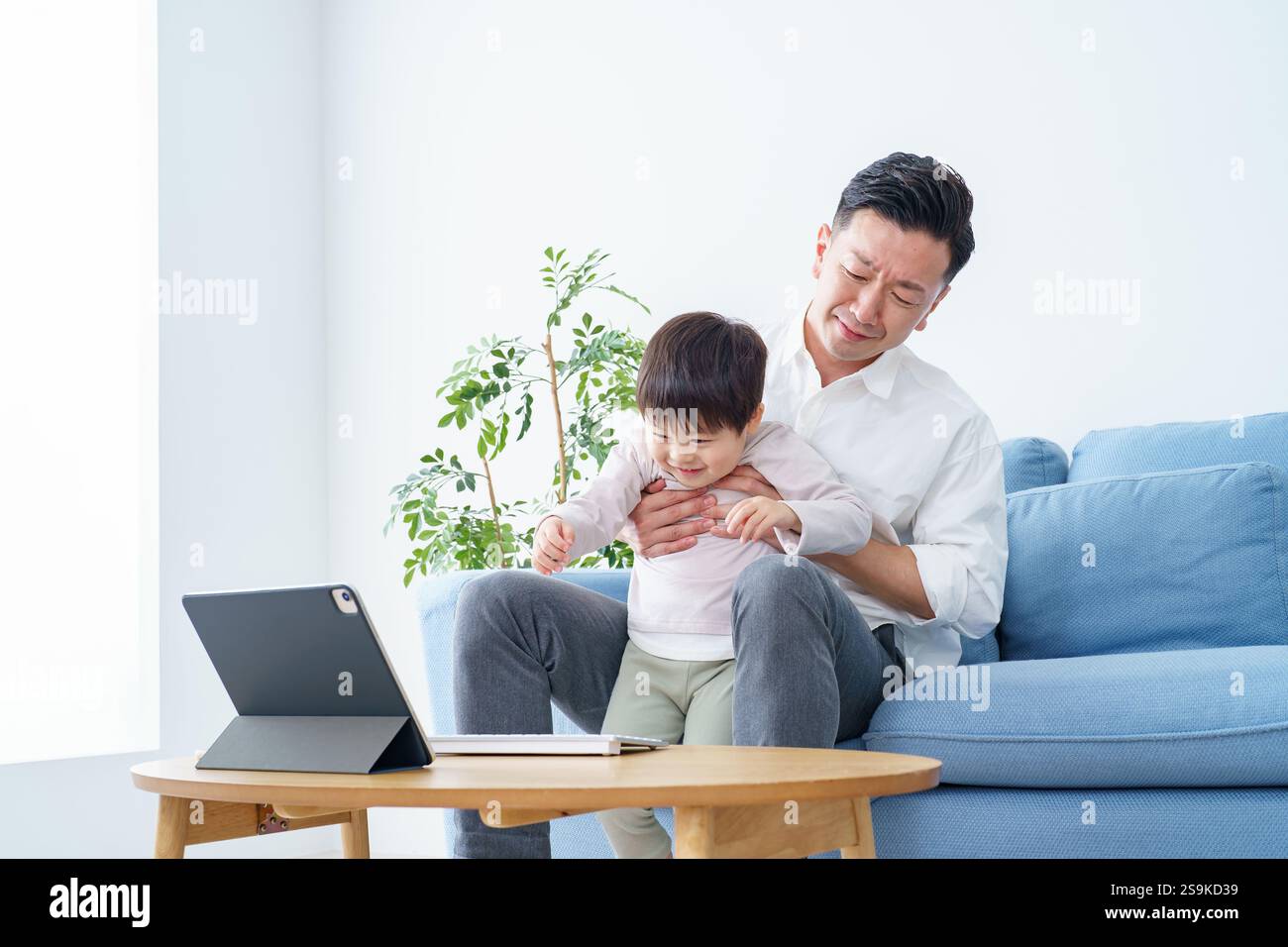 Child interrupting father teleworking Stock Photo - Alamy