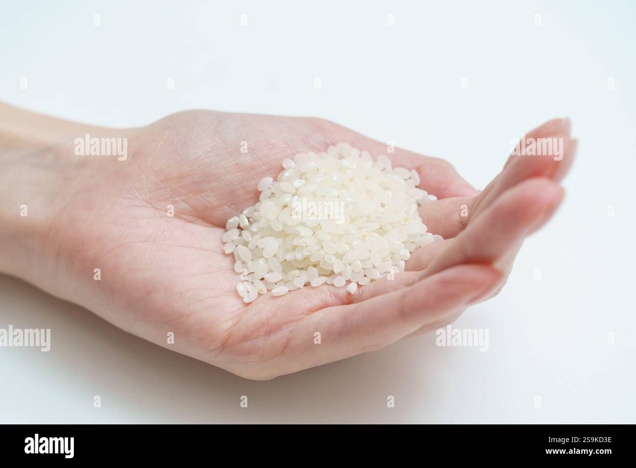 One hand holding the white rice Stock Photo - Alamy