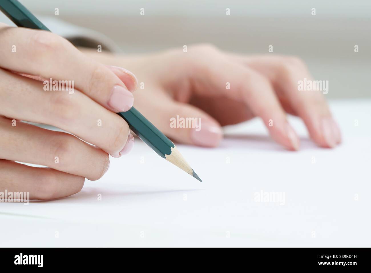 Woman's hand holding pencil Stock Photo - Alamy