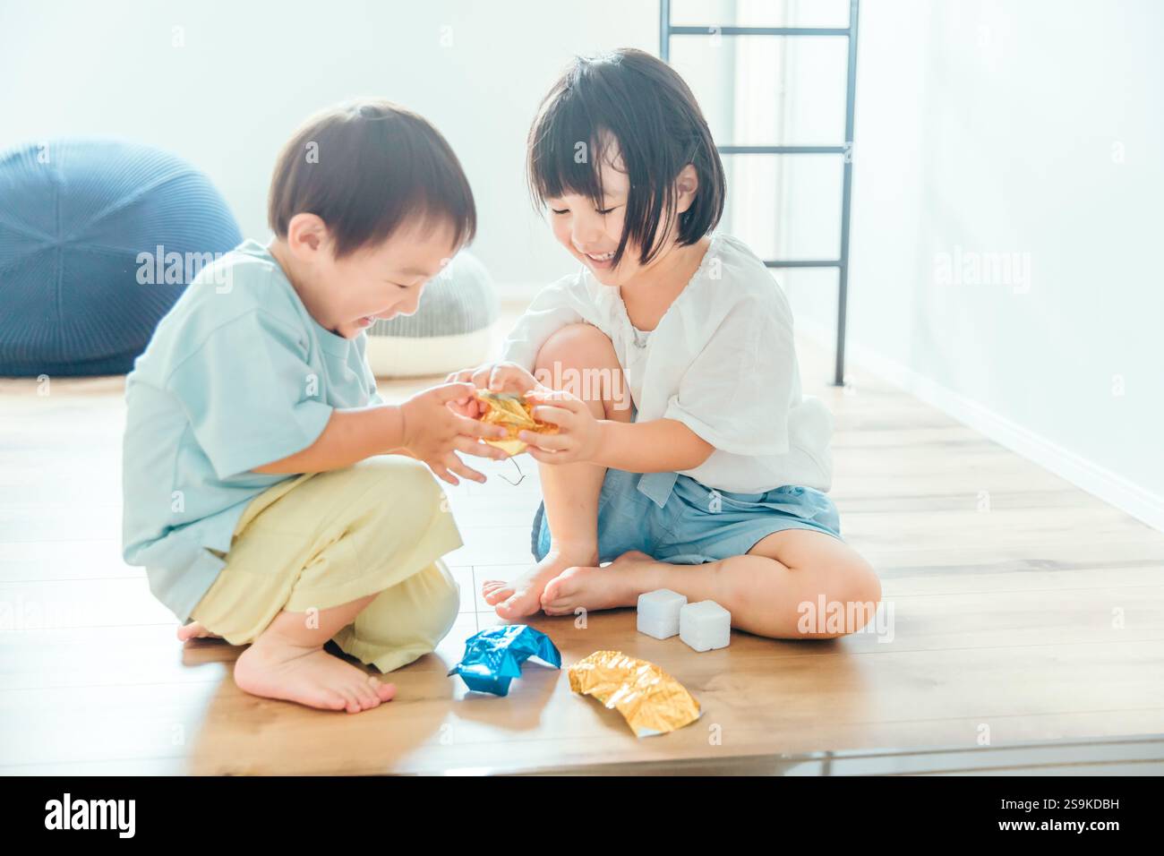 Smiling siblings playing together in room Stock Photo - Alamy