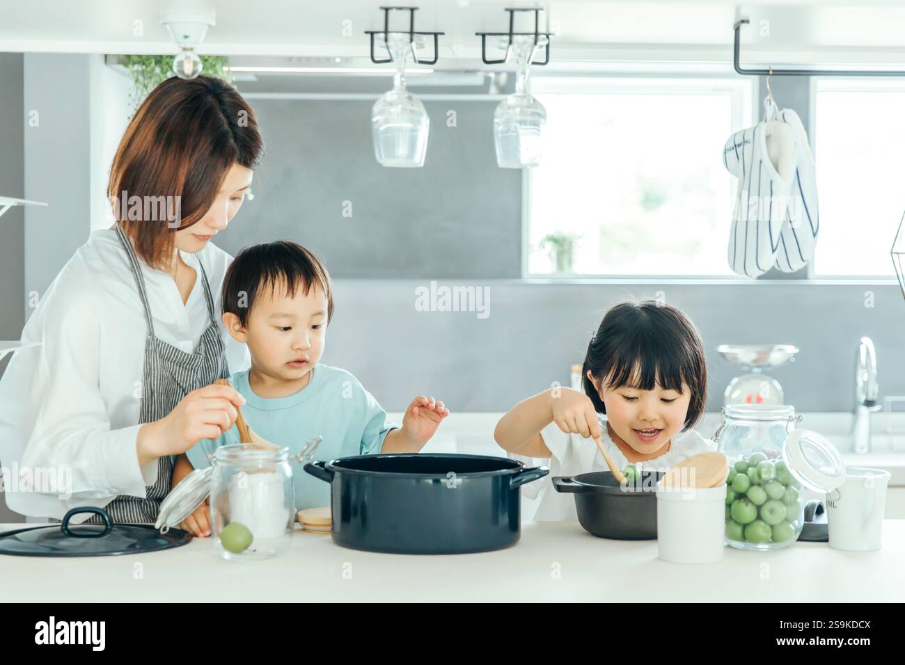 Girl and boy cooking with their mother Stock Photo - Alamy