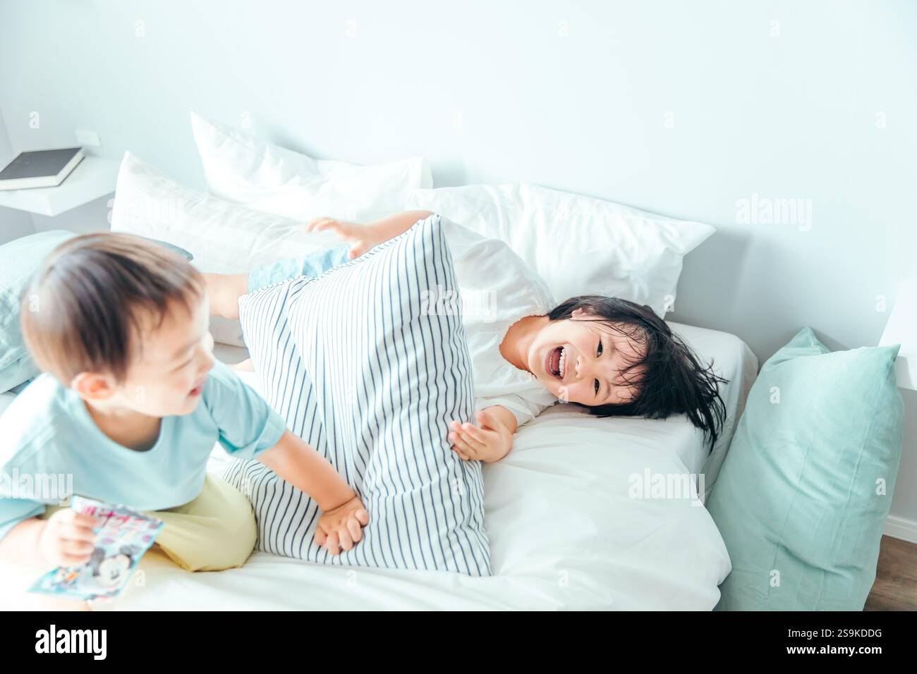 Child playing in bed, pillow thrower Stock Photo - Alamy