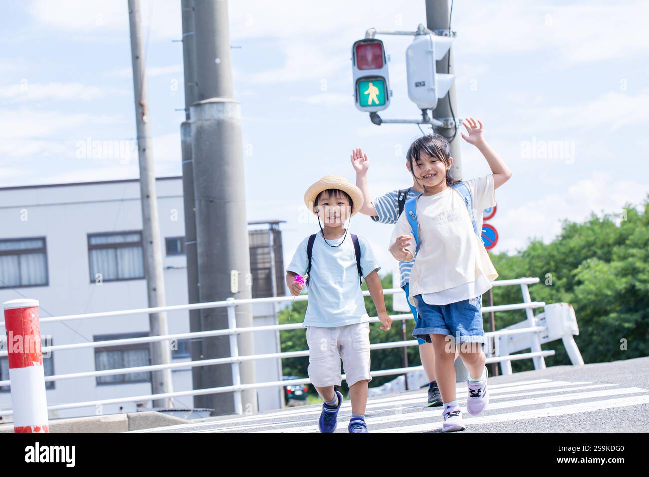 Child crossing a pedestrian crossing with hands raised Stock Photo - Alamy