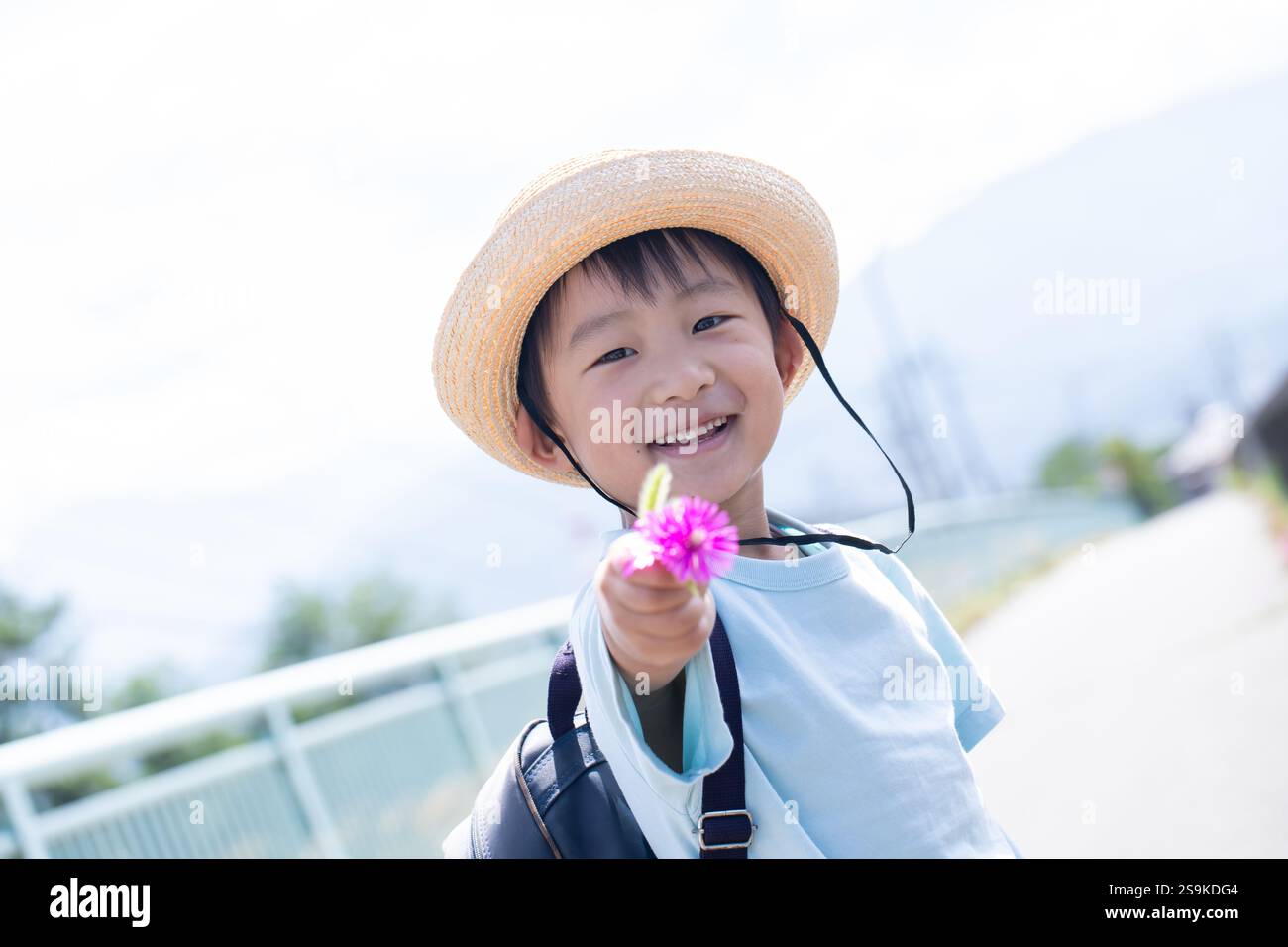 Boy smiling at picked flowers Stock Photo - Alamy