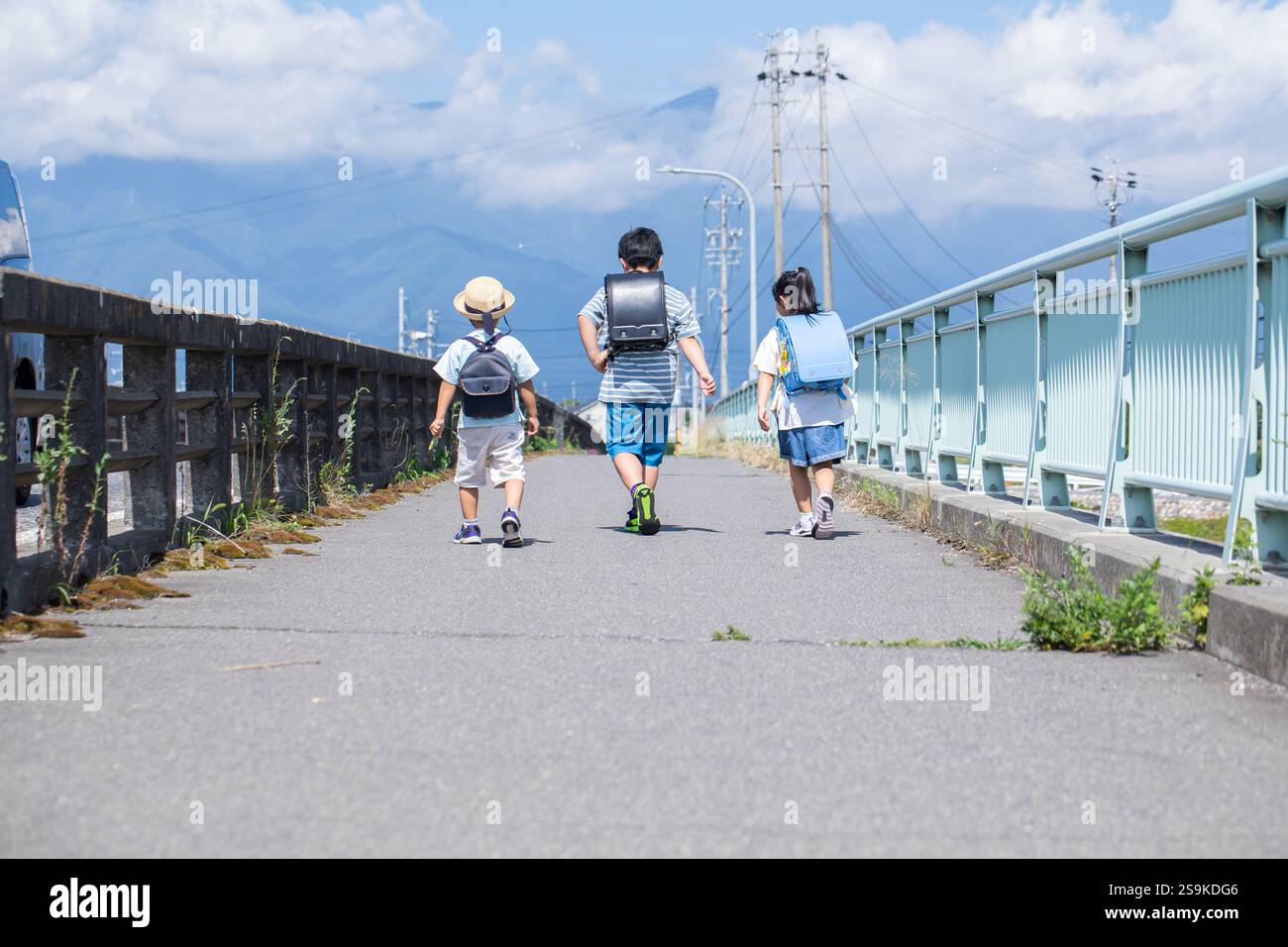 Primary school and kindergarten children, siblings and three siblings walking on the road Stock ...