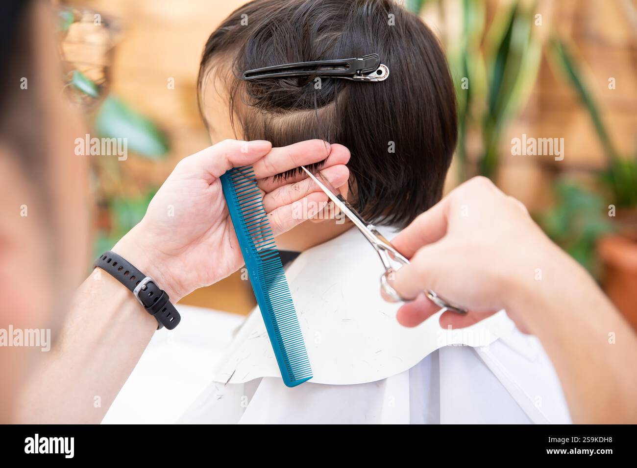 Boy getting haircut by hairdresser, beauty salon Stock Photo - Alamy