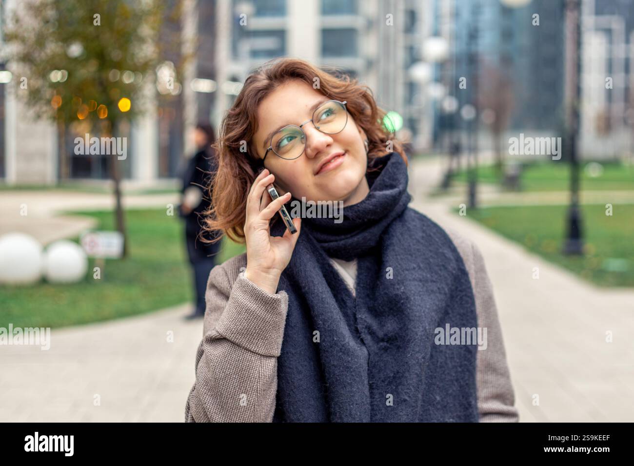 Cute teenage girl talking on the phone on the street. Girl in the city ...