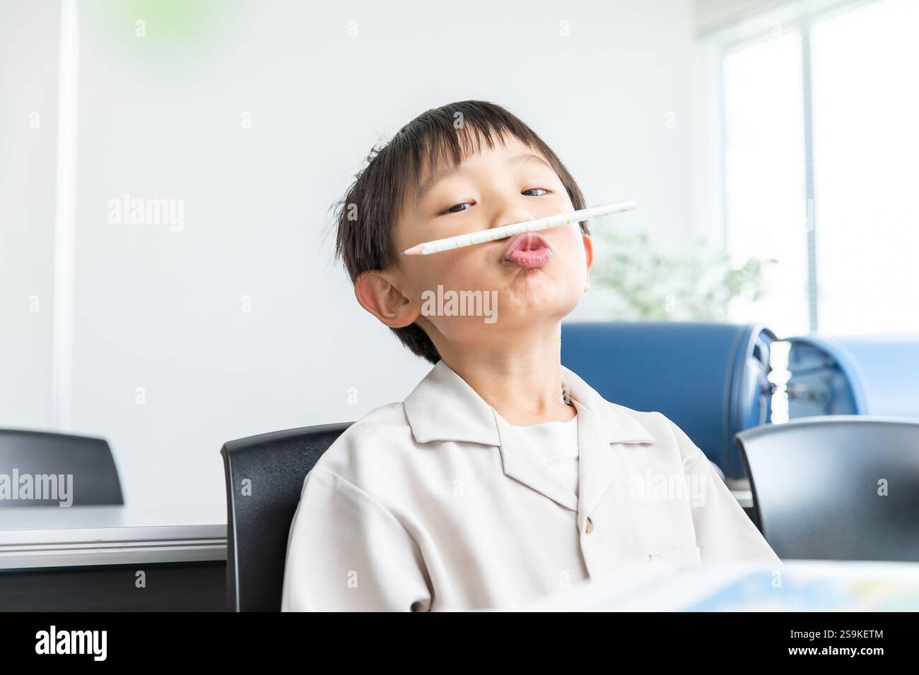 Primary school child goofing off in the classroom Stock Photo - Alamy