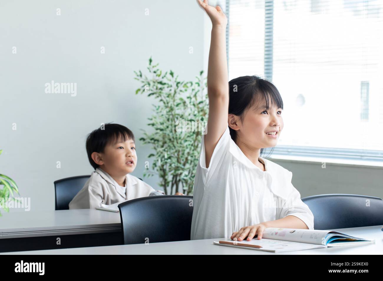 Students in class raise hands hi-res stock photography and images - Alamy