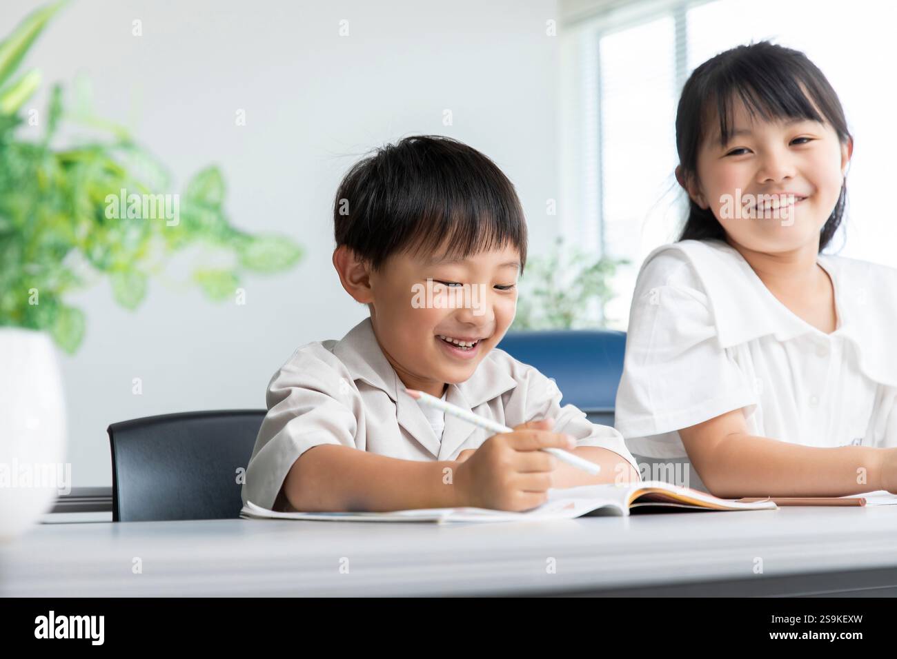 Primary schools students studying in a classroom Stock Photo - Alamy