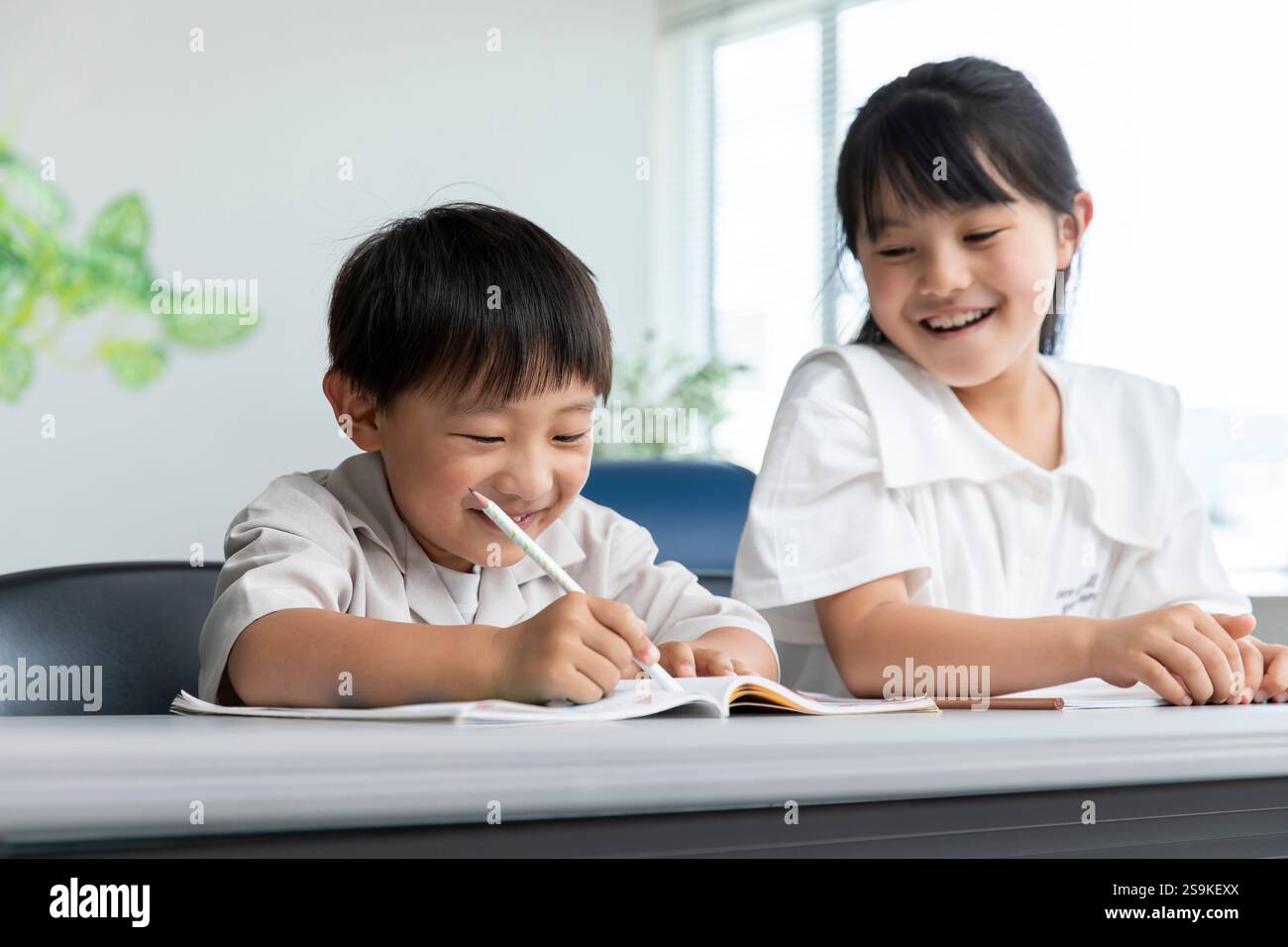 Primary schools students studying in a classroom Stock Photo - Alamy