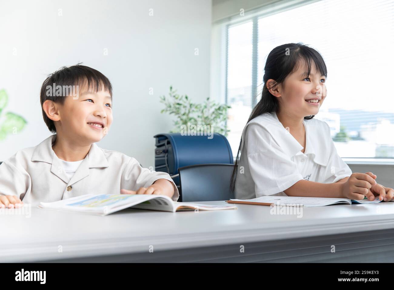 Primary schools students studying in a classroom Stock Photo - Alamy