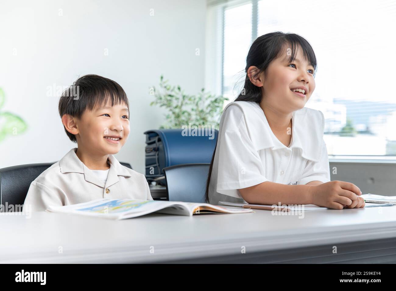 Primary schools students studying in a classroom Stock Photo - Alamy