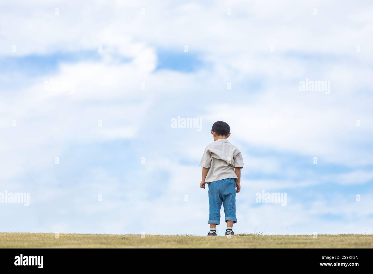 Child standing alone on hill Stock Photo - Alamy